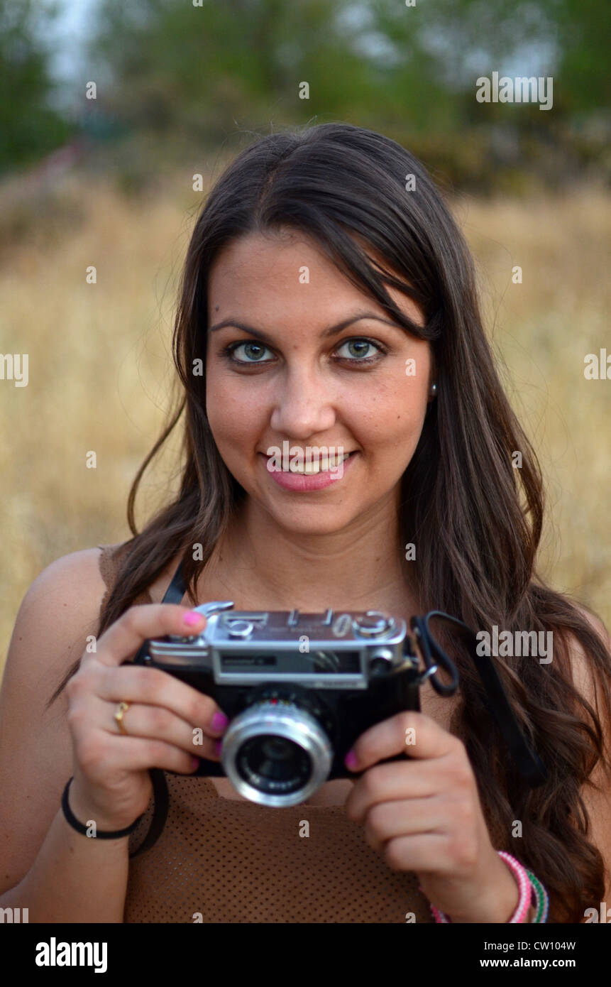 Cute young woman using an old camera Stock Photo - Alamy