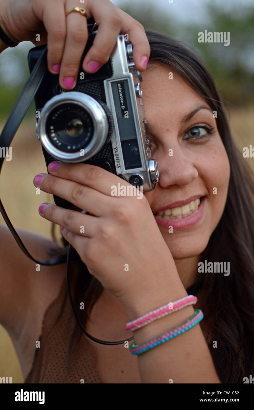 Cute young woman using an old camera Stock Photo - Alamy