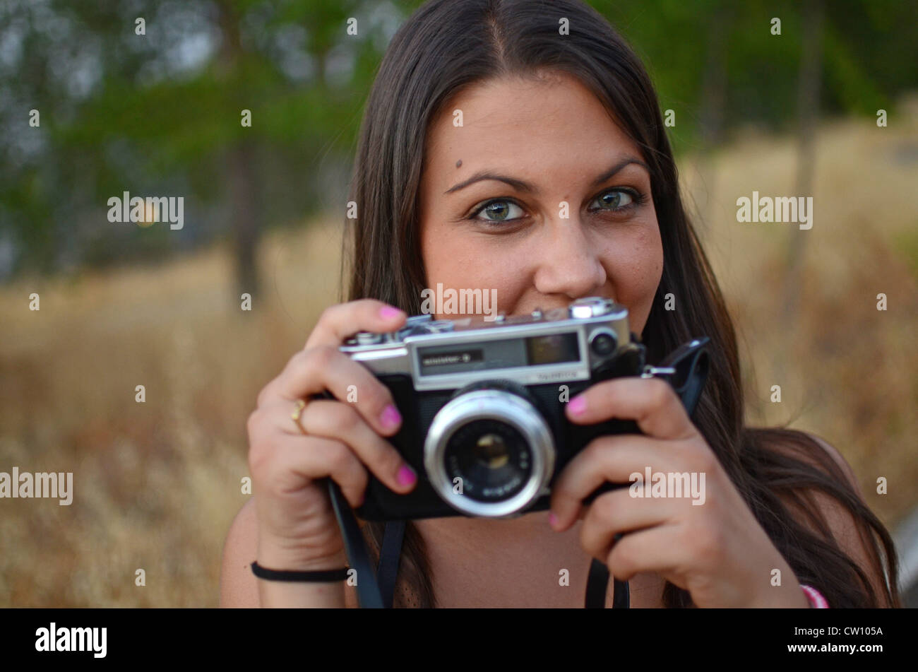 Cute young woman using an old camera Stock Photo - Alamy