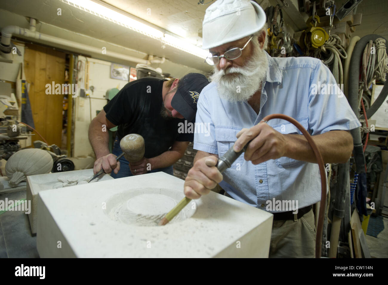 Stonecarver chiseling feature on sculpture Stock Photo - Alamy
