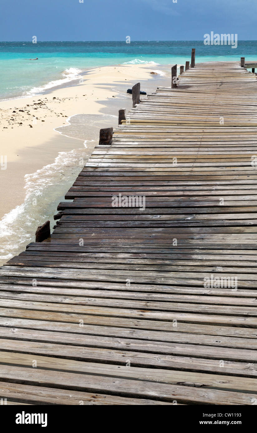 A rickety dock stretches out into turquoise water off Goff's Caye in ...