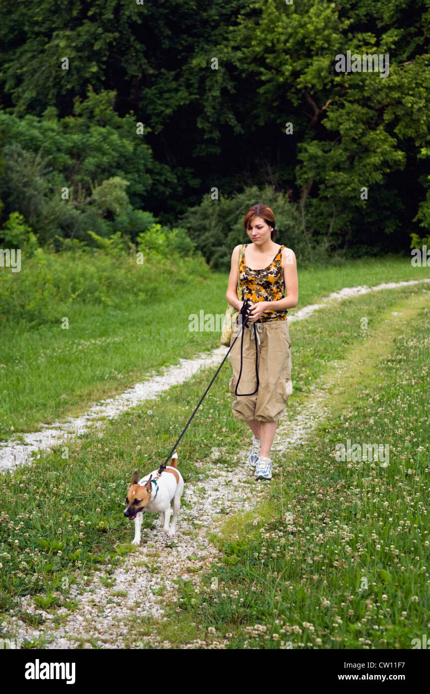 Young Woman Walking Jack Russell Terrier ialong Gravel Road at Mount ...