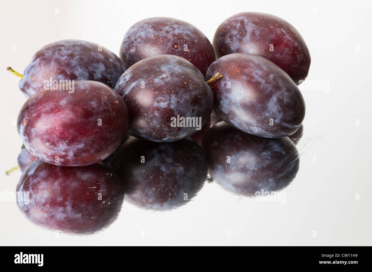 Blue prunes or plums on reflective surface Stock Photo - Alamy