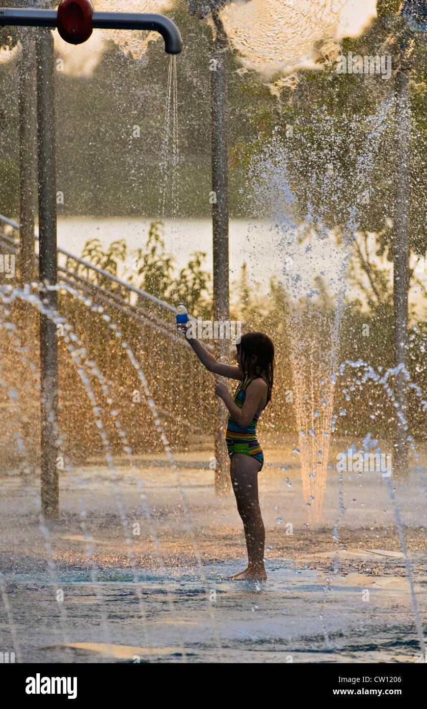 Girl playing in water fountain hi-res stock photography and images - Alamy
