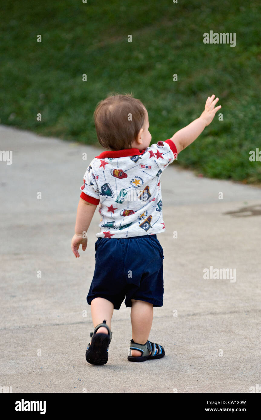 Little Boy Walking on Sidewalk and Waving at Waterfront Park in ...