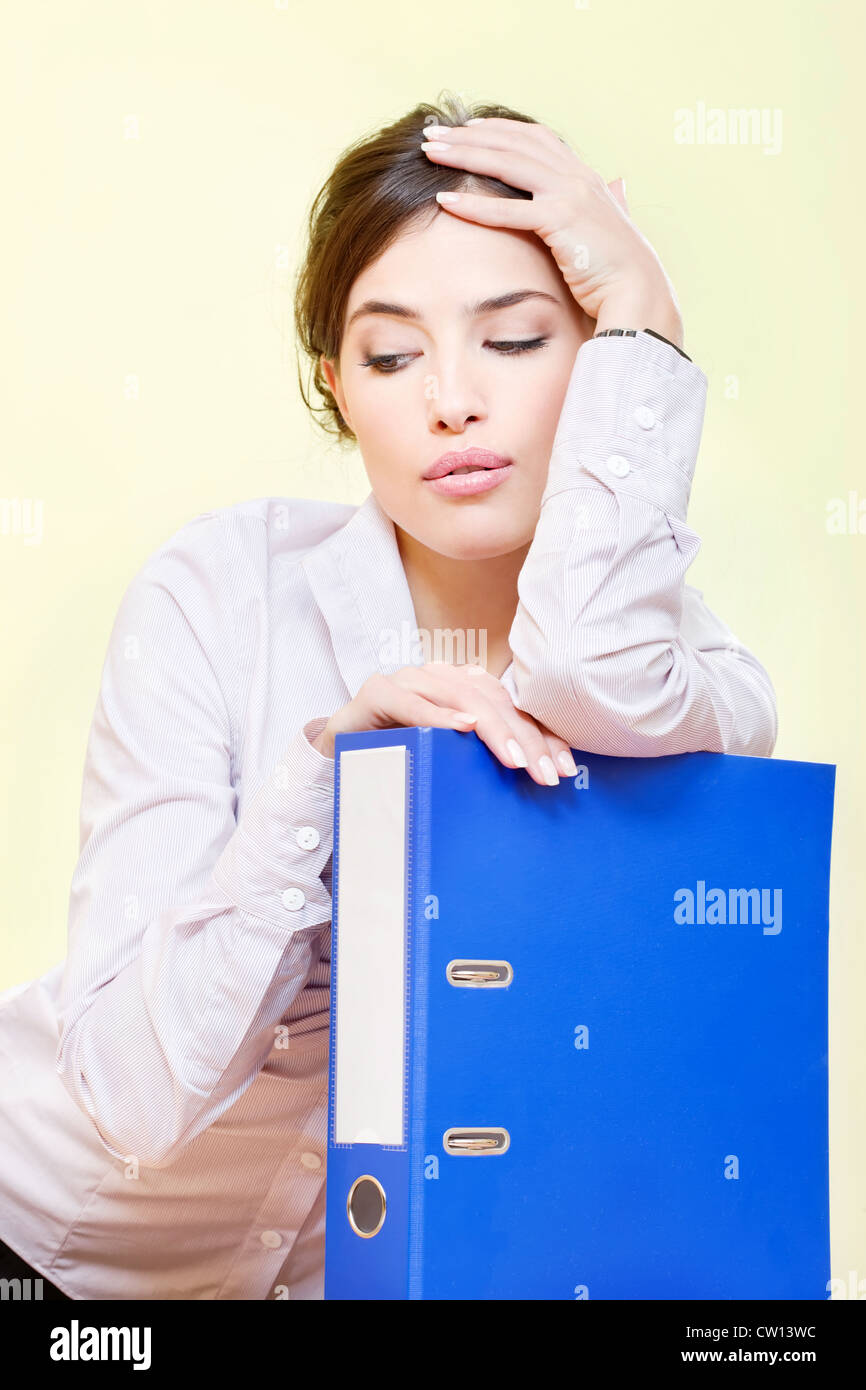 Serious or bored business woman with files Stock Photo - Alamy