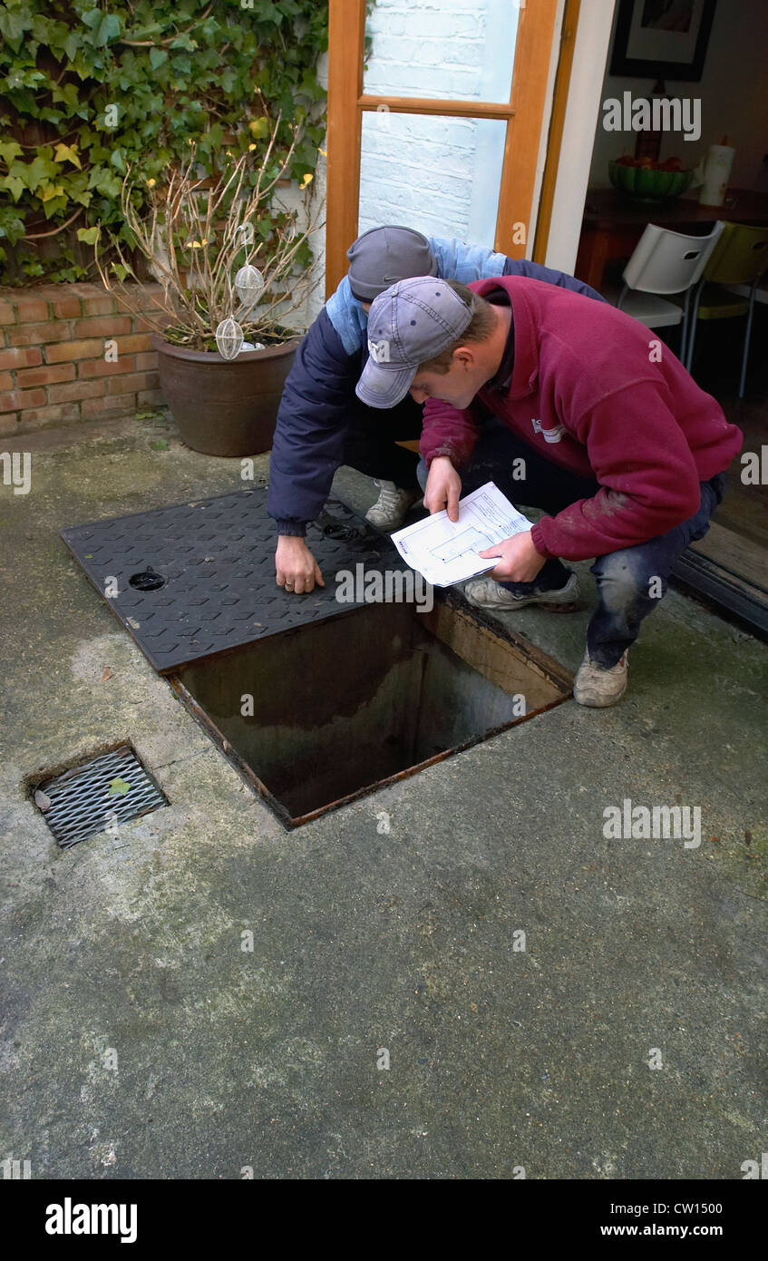 Builder inspecting a manhole Stock Photo - Alamy