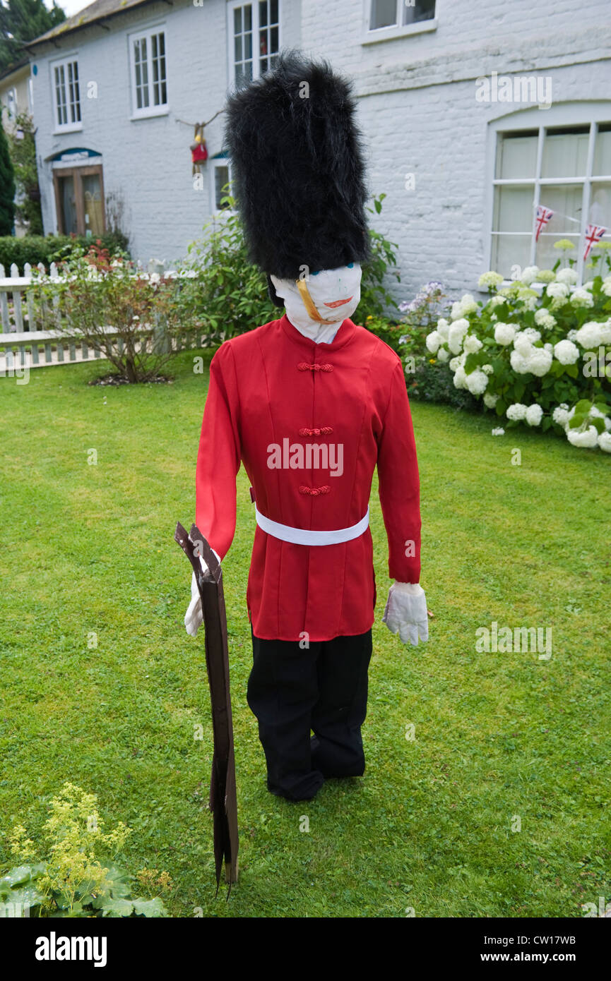 Guardsman on lawn of garden outside house on Scarecrow Day in village ...