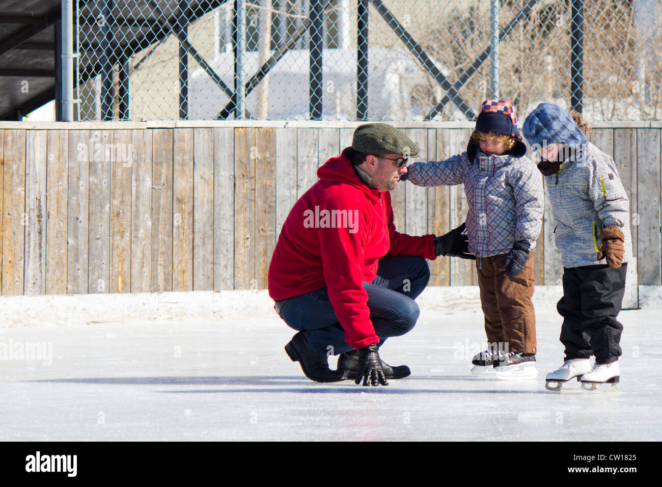 Family having fun at the outdoor skating rink in winter Stock Photo - Alamy