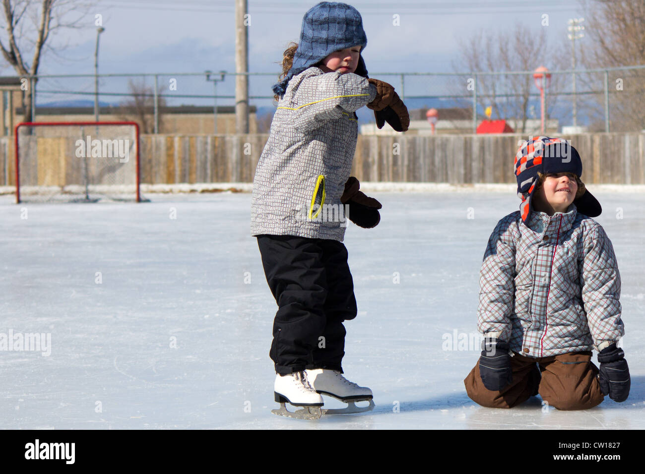Children playing and skating at the outdoor skating rink during winter ...