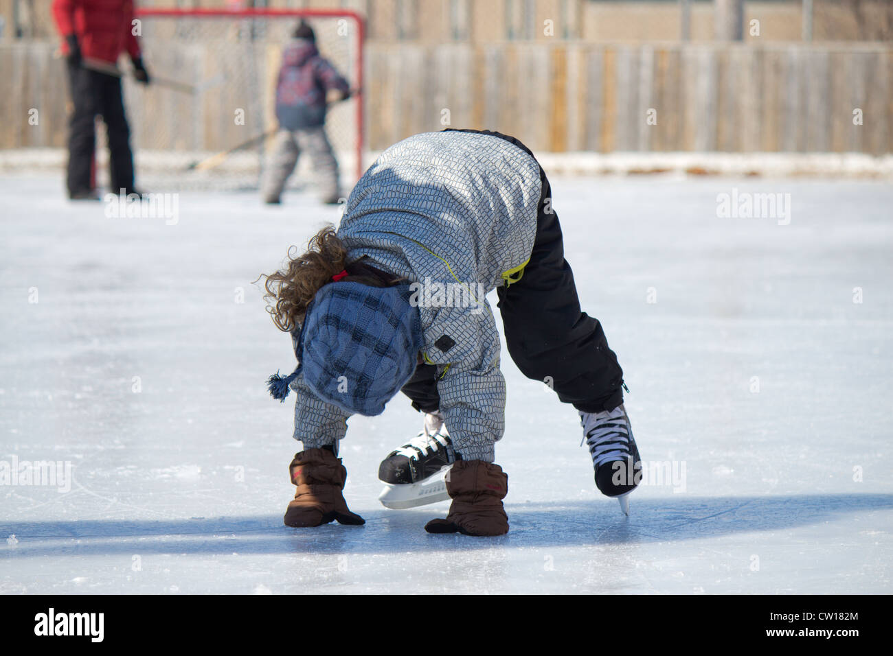Child playing and skating at the outdoor skating rink in winter Stock ...