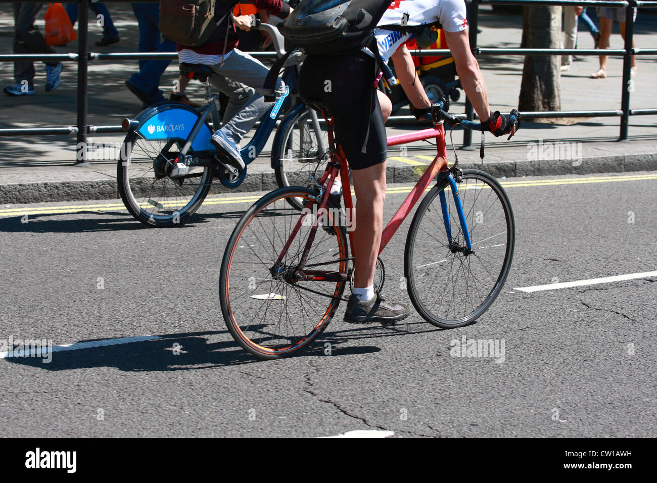 Two cycles being ridden along a road in London Stock Photo - Alamy