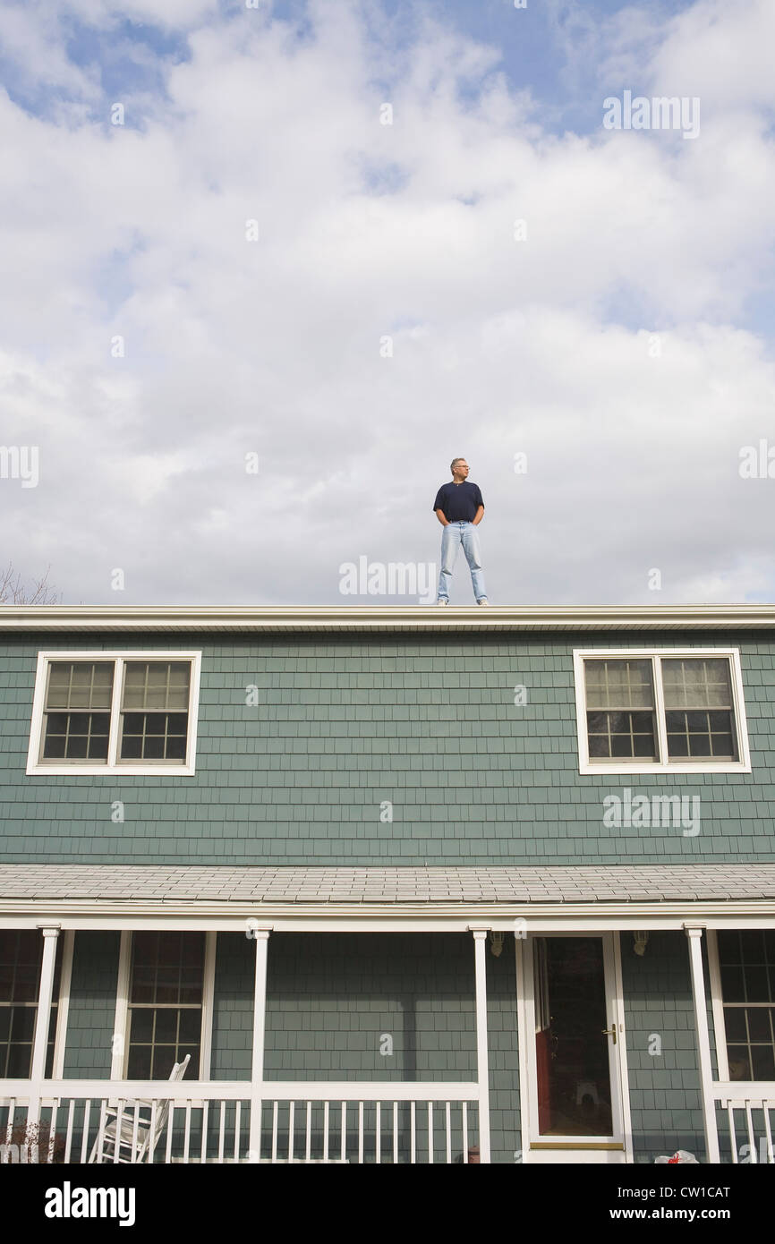Man on Roof of Home Stock Photo - Alamy