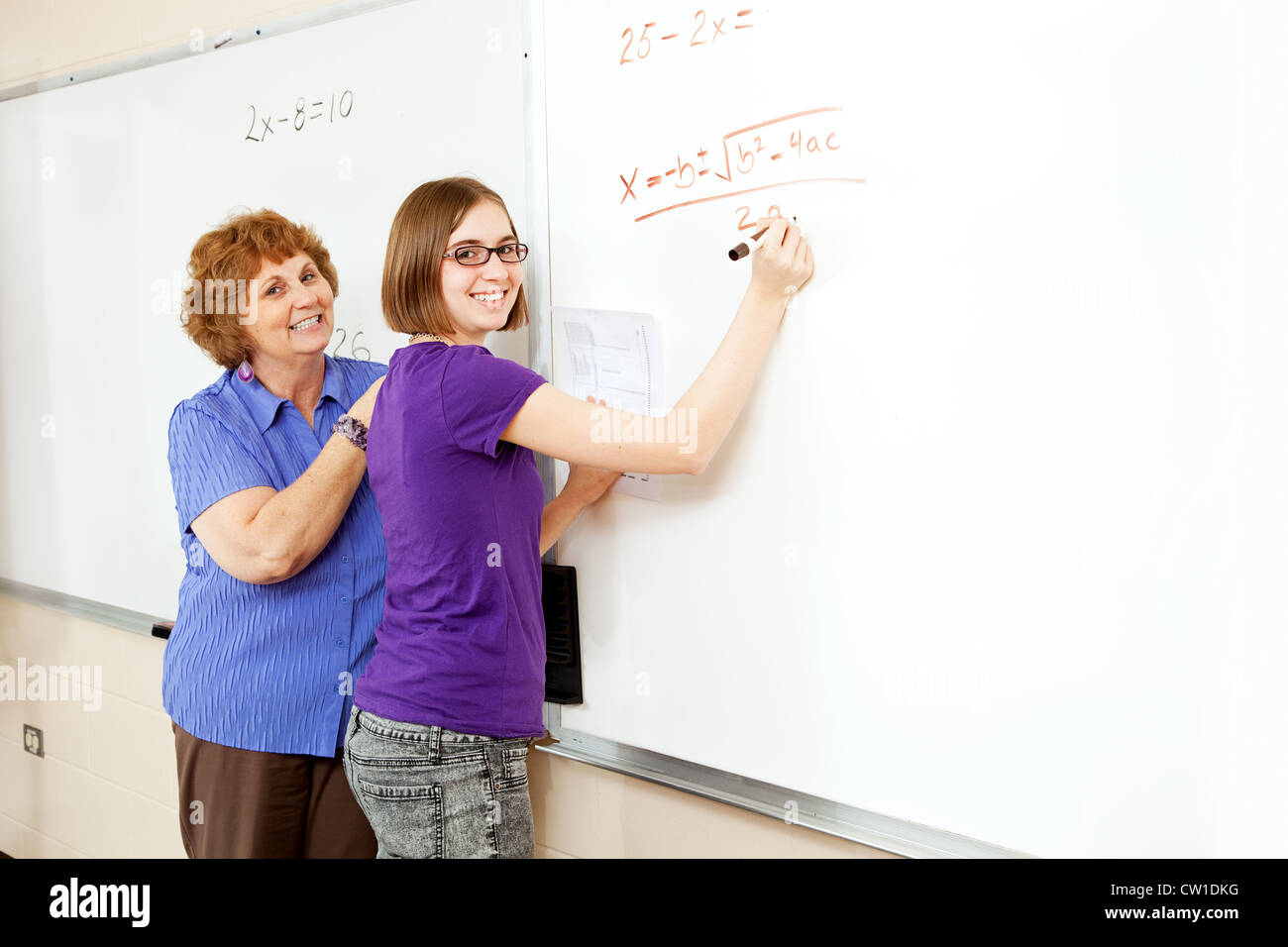Math student and teacher working problems on the white board, with ...