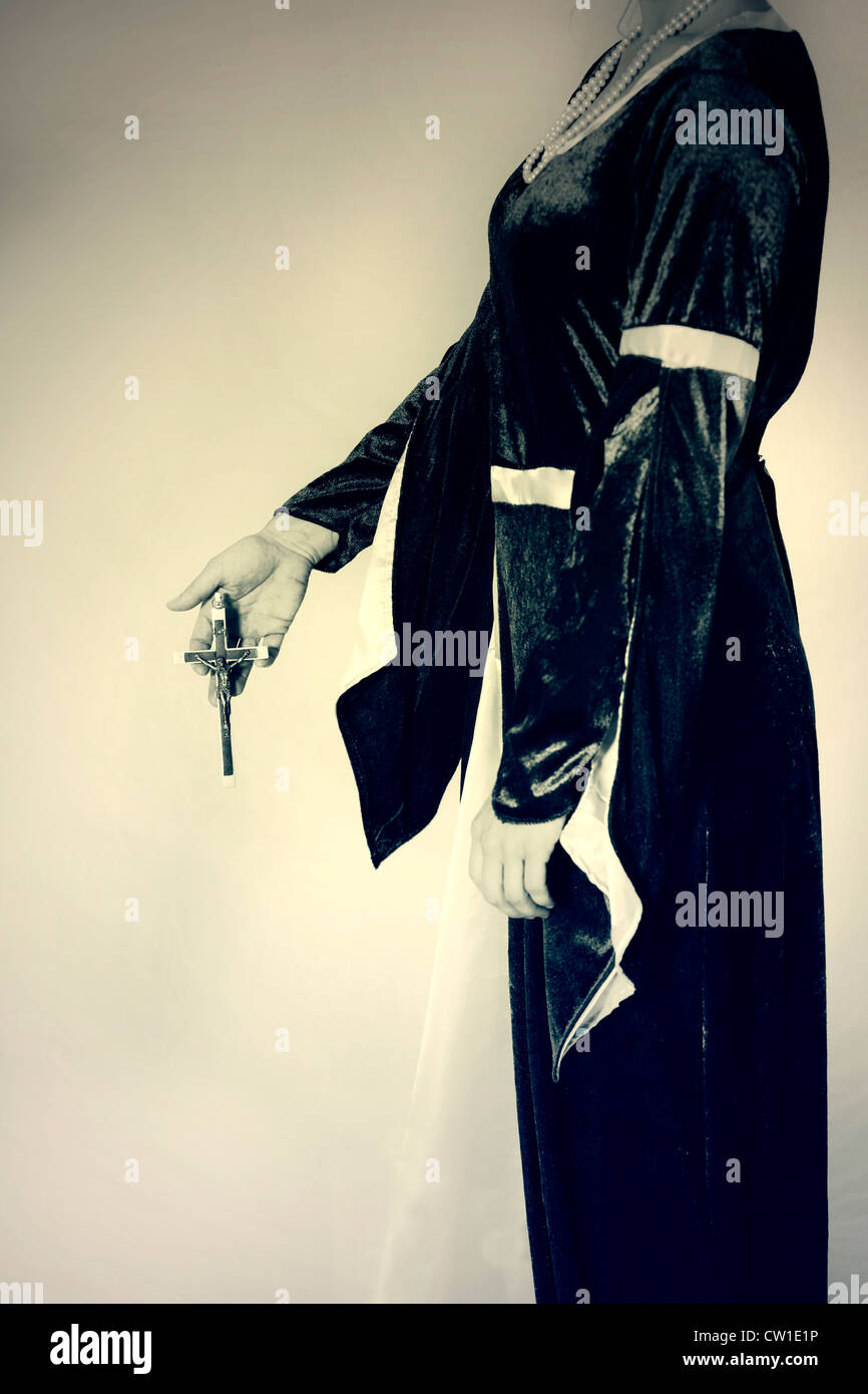 a woman in Victorian dress holding a crucifix in her hands Stock Photo ...