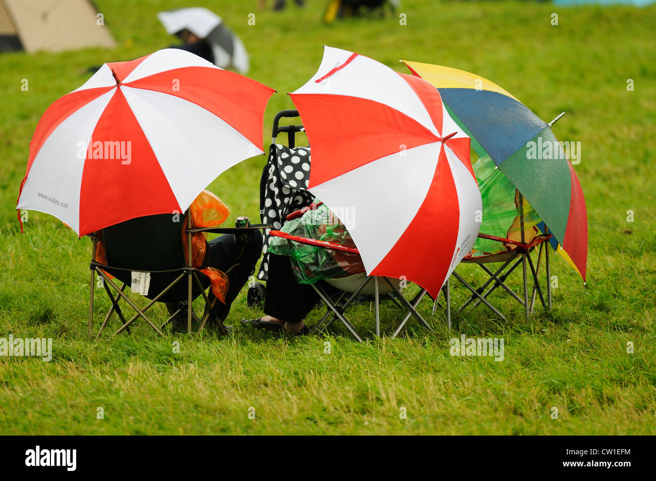 Hiding under umbrellas at an event during the 2012 Summer Stock Photo ...