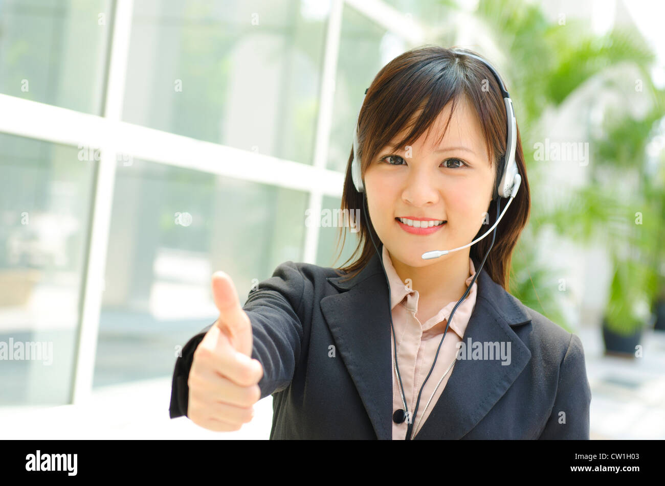 Friendly Customer Representative with headset thumb up during a ...