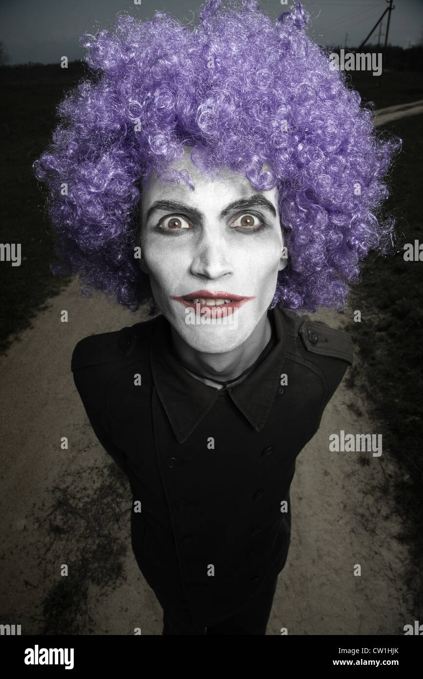 Crazy man outdoors with wig and clown makeup. Artistic darkness and ...