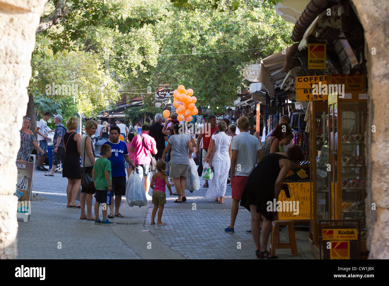 A busy street in old town Rhodes with a backdrop of Rhodes Turkish ...