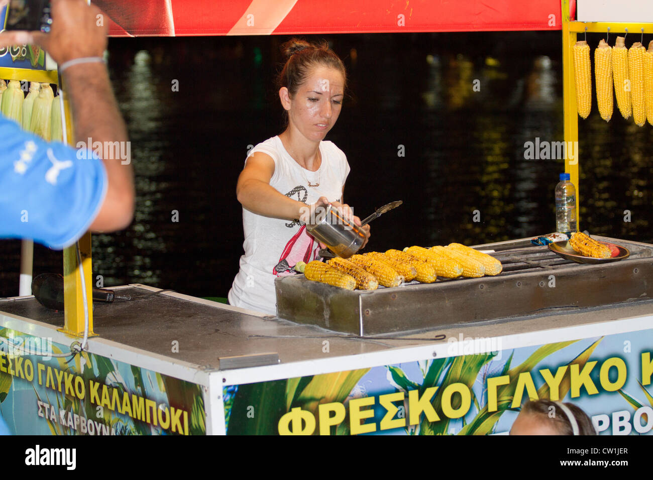 A street trader selling hot fast food corn on the cobs in Rhodes Town ...