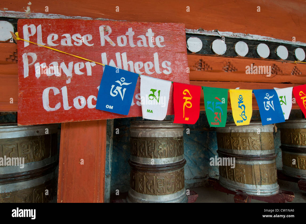 Prayer wheels, small prayer flags and sign that reads "Please Rotate ...
