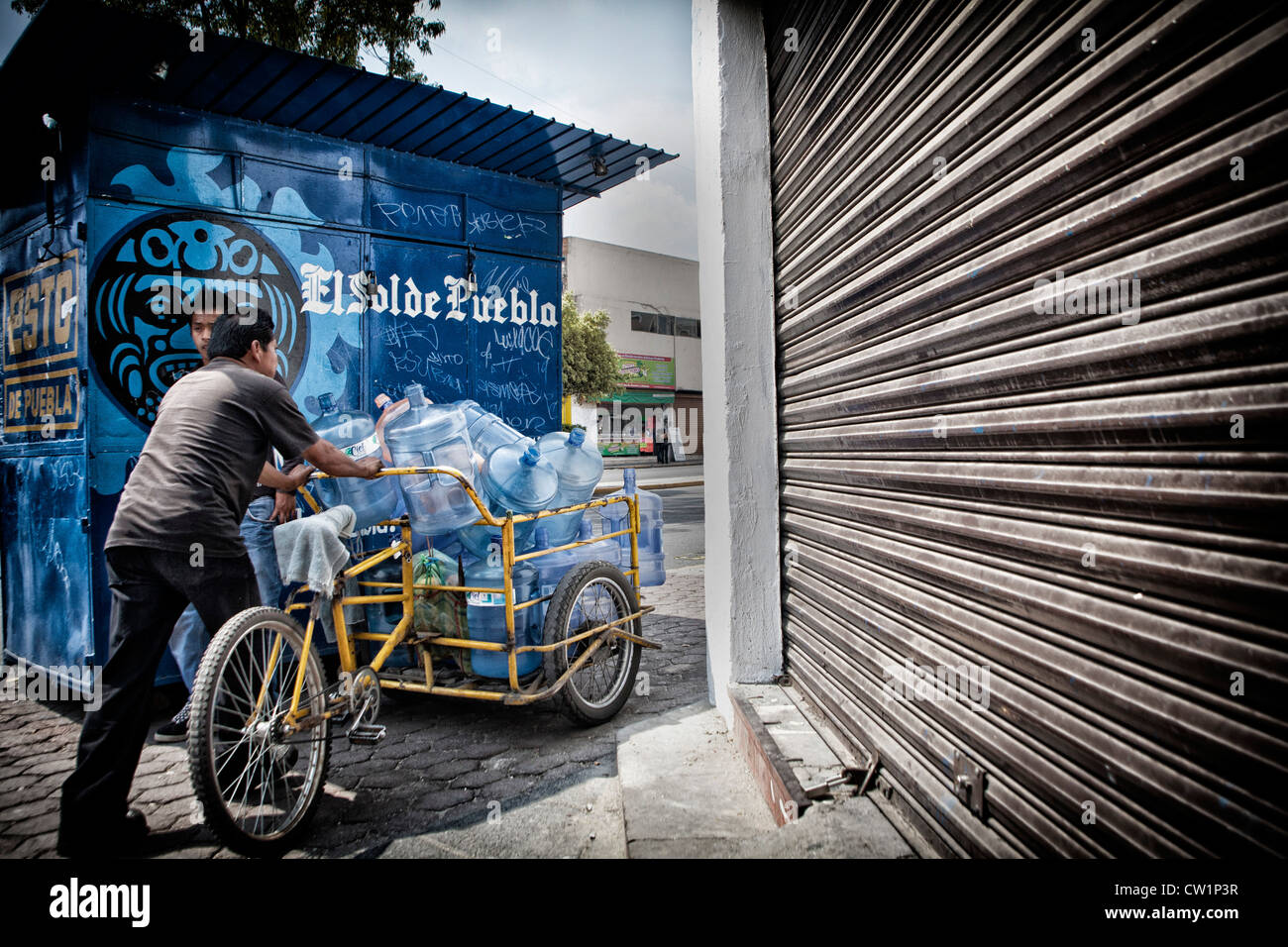Man pushing cart of empty water bottles in Puebla, Mexico Stock Photo ...