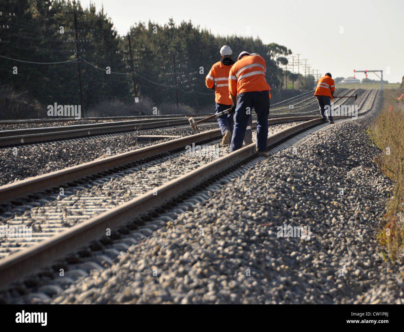 Track workers performing maintenance on rail track Stock Photo - Alamy