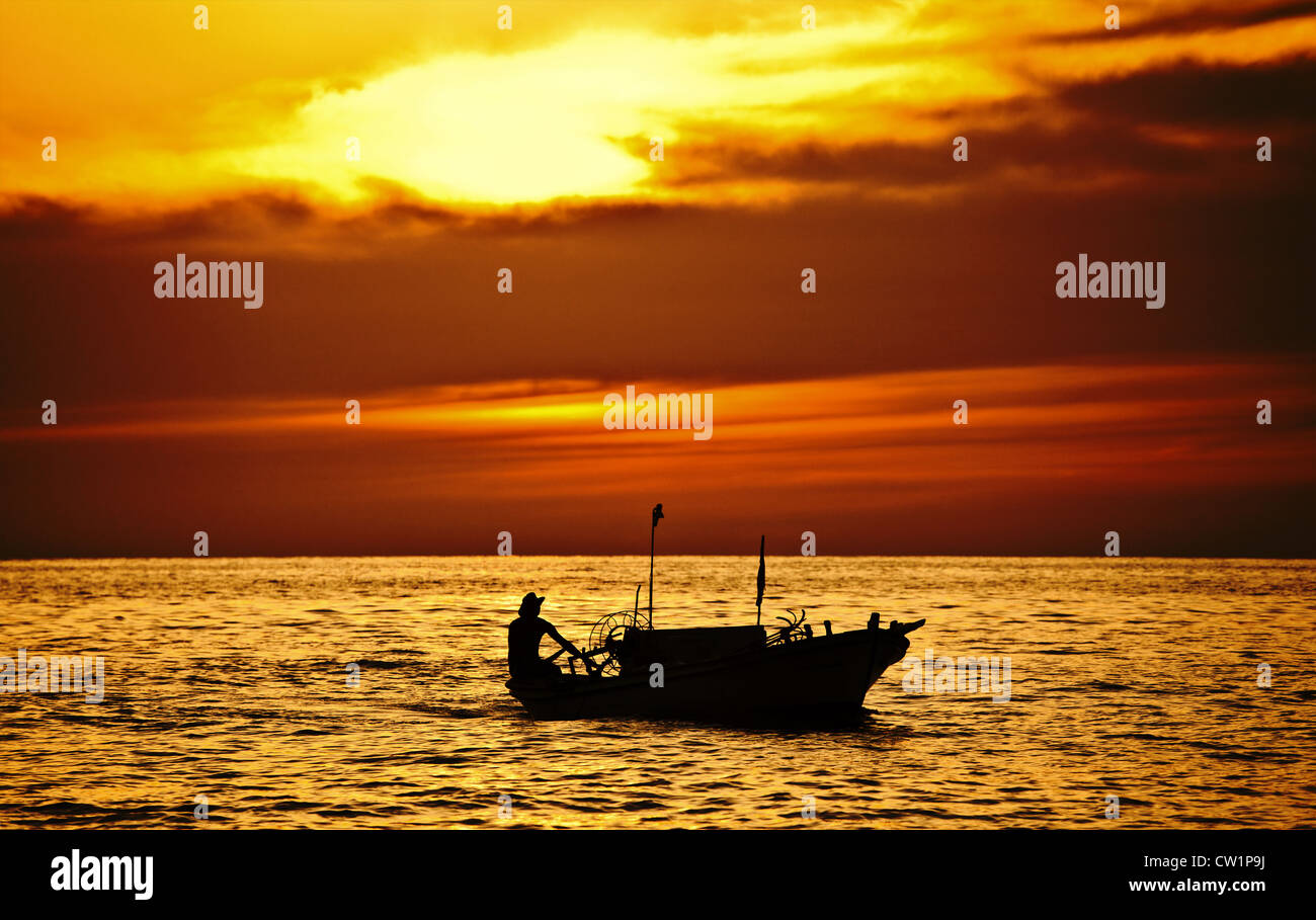 Fisherman on the boat over dramatic sunset, male on vessel, beautiful ...