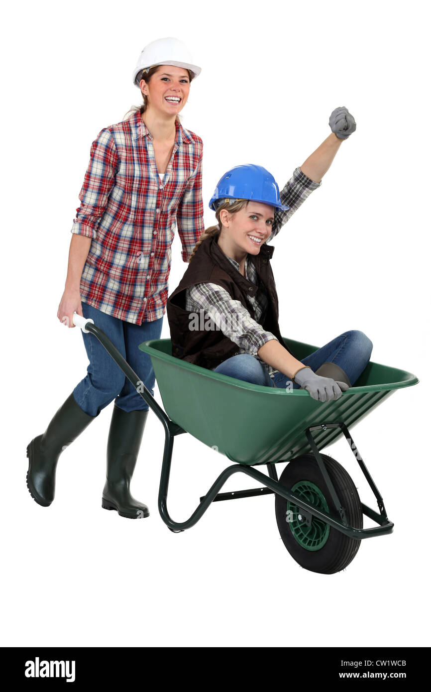 Two female construction workers with wheelbarrow Stock Photo - Alamy