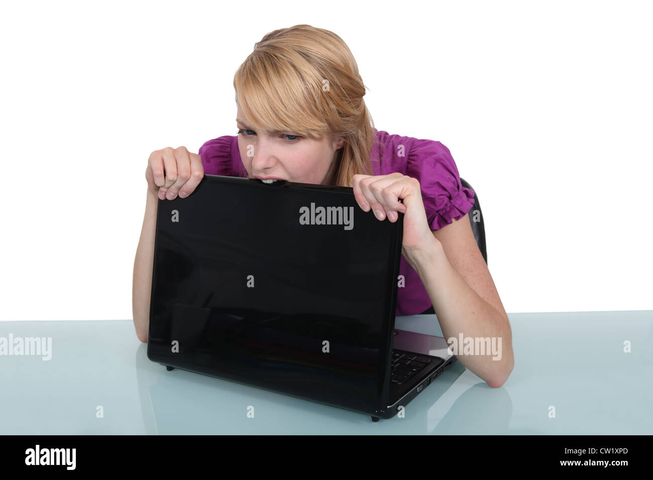 cute blonde biting computer Stock Photo - Alamy
