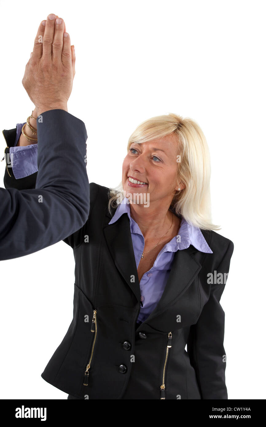 Senior businesswoman giving a high-five Stock Photo - Alamy