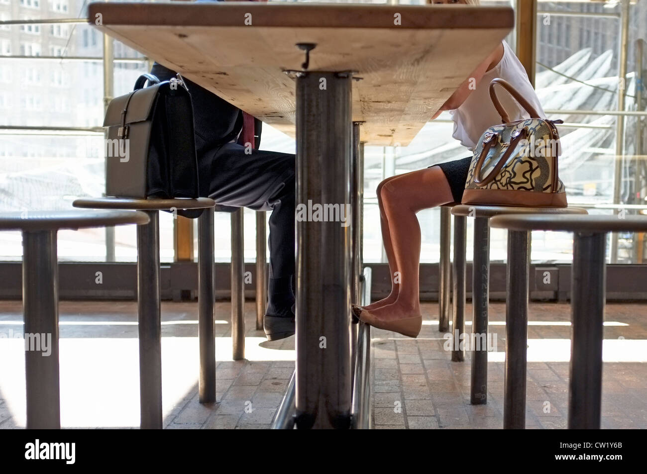 Man and Woman Sitting Face to Face at a High Cafe Table Stock Photo - Alamy