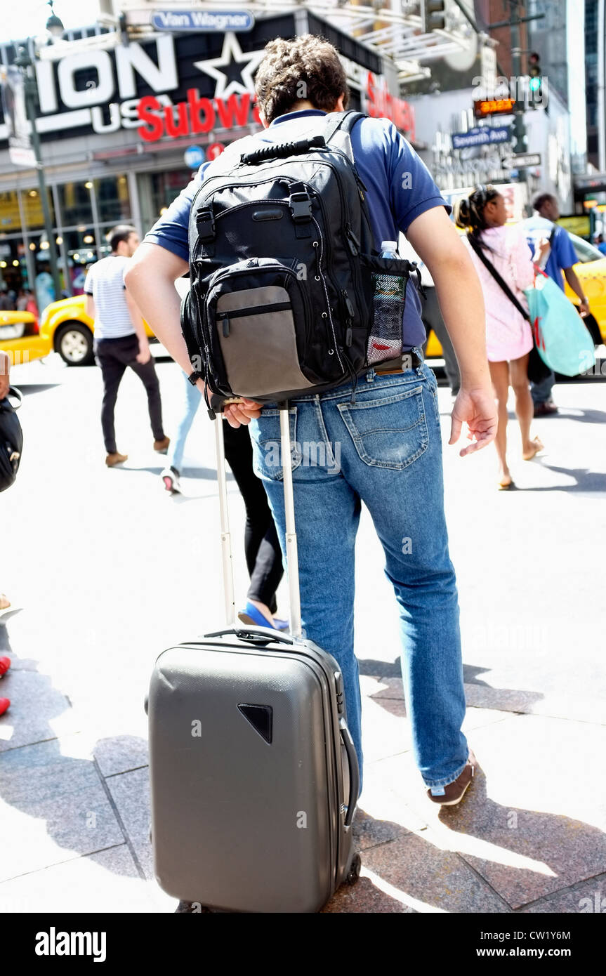 Young Man With Luggage Trudging Along a City Street Stock Photo - Alamy