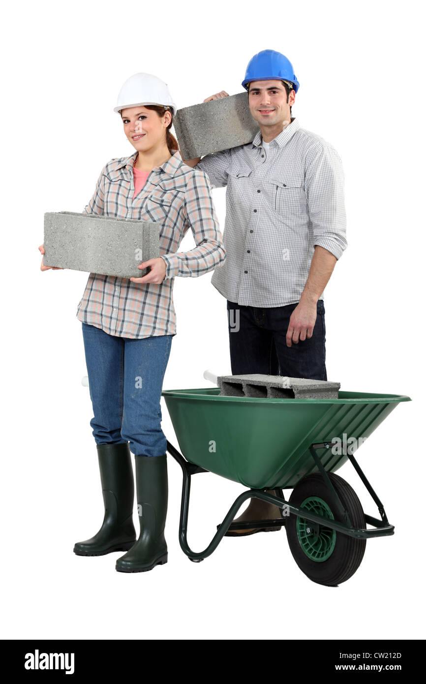 Construction workers carrying cinder blocks Stock Photo - Alamy