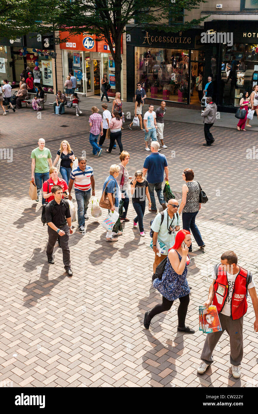 Shoppers pass by a Big Issue seller on Listergate, Nottingham. Phones ...