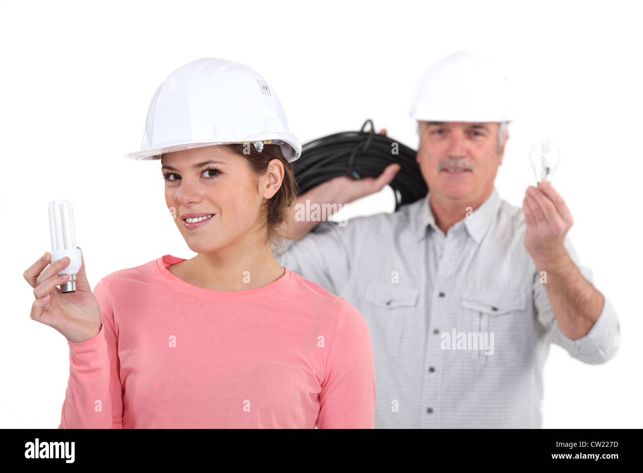 Team holding up light bulb against rocky landscape Stock Photo - Alamy
