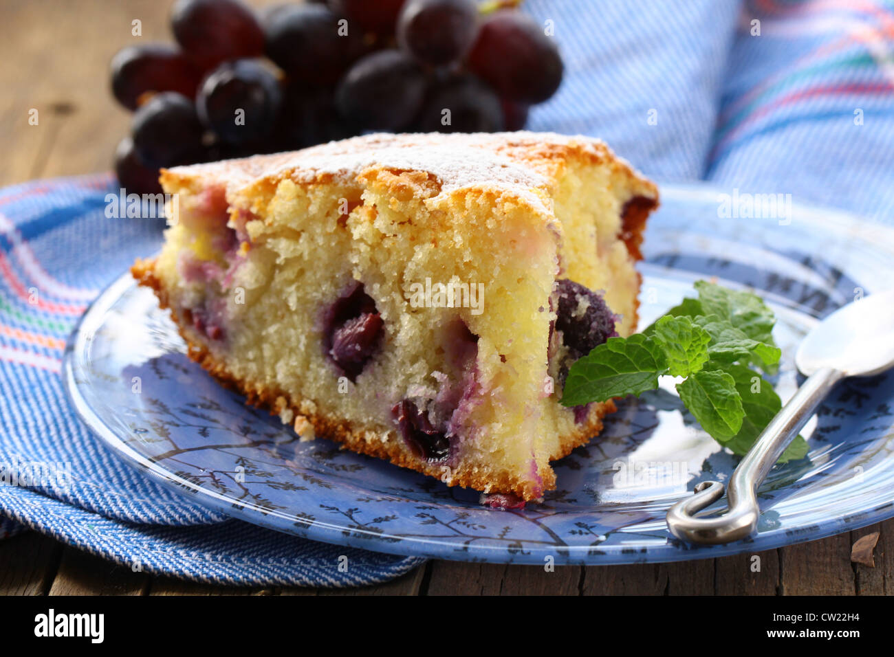 sponge cake with red grapes on a plate Stock Photo - Alamy