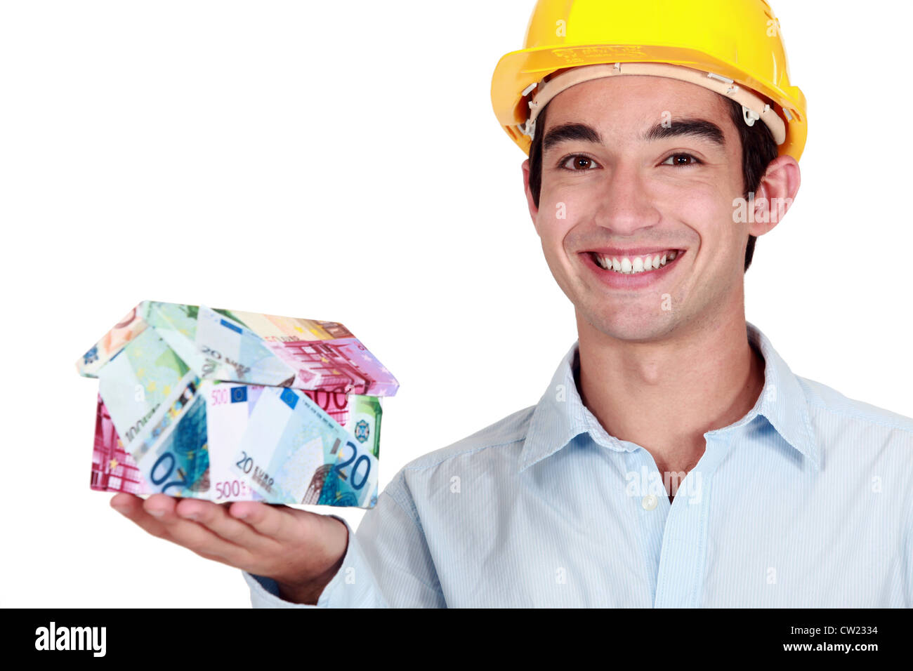 An architect holding a miniature of a house made of banknotes Stock ...