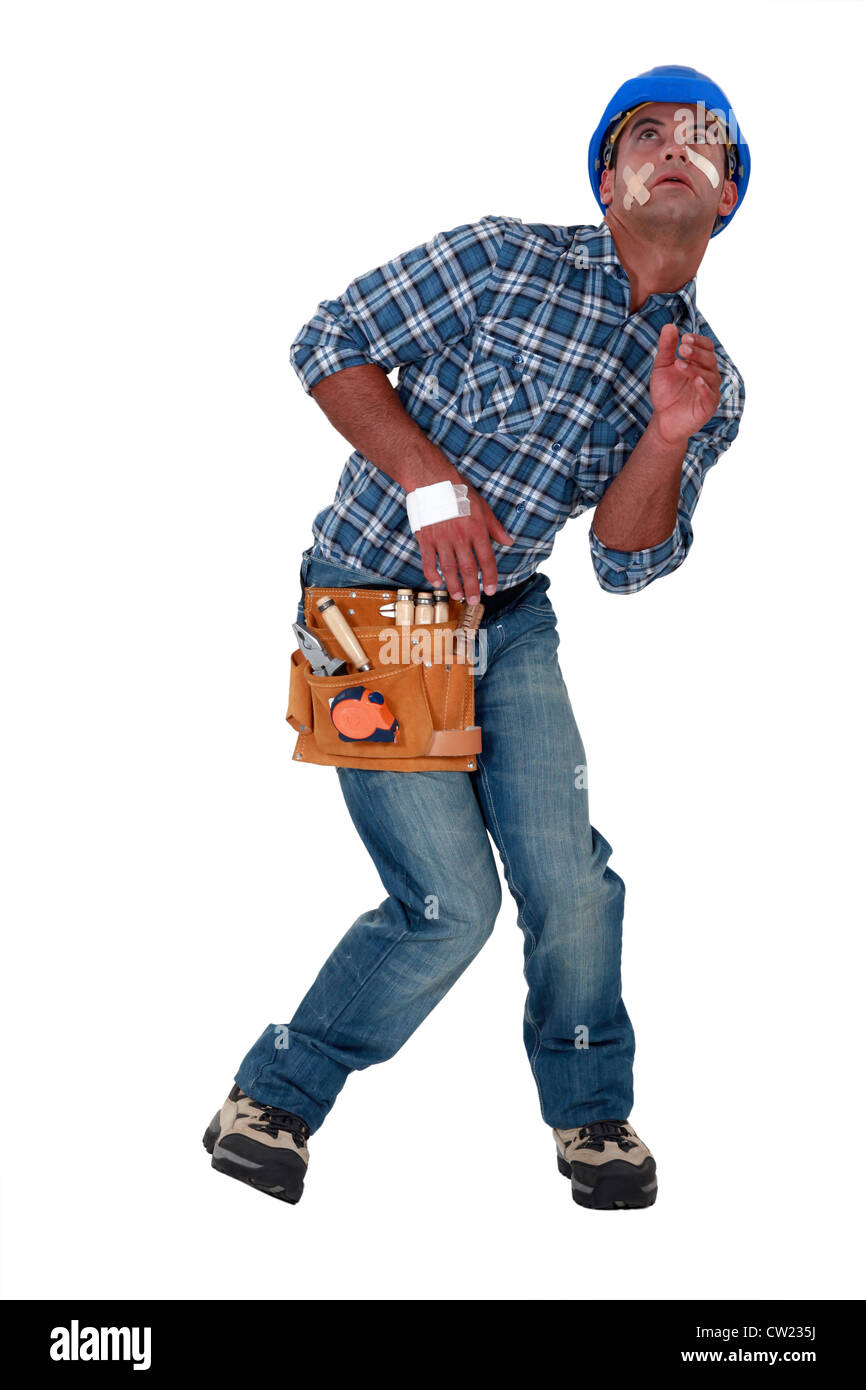 Scared builder covered in plasters after accident Stock Photo - Alamy
