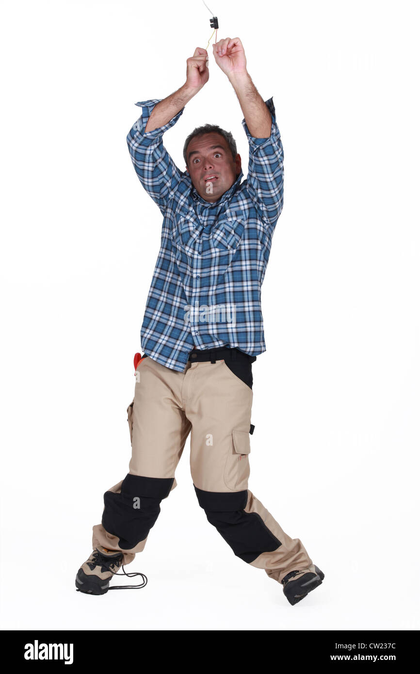 Electrician getting a shock from a light socket Stock Photo - Alamy