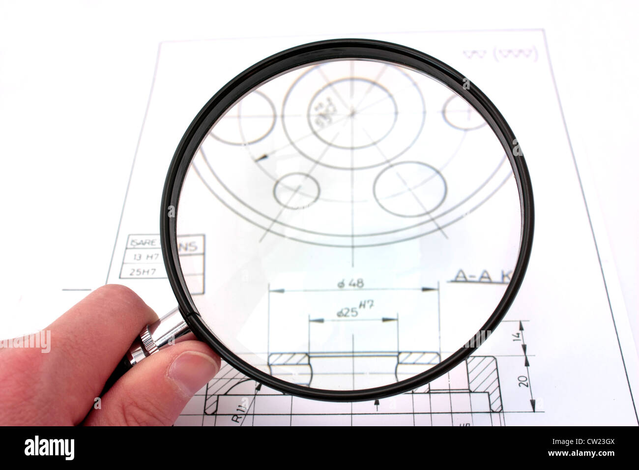 Reviewing technical drawing with magnifying glass. Focus on magnifying ...