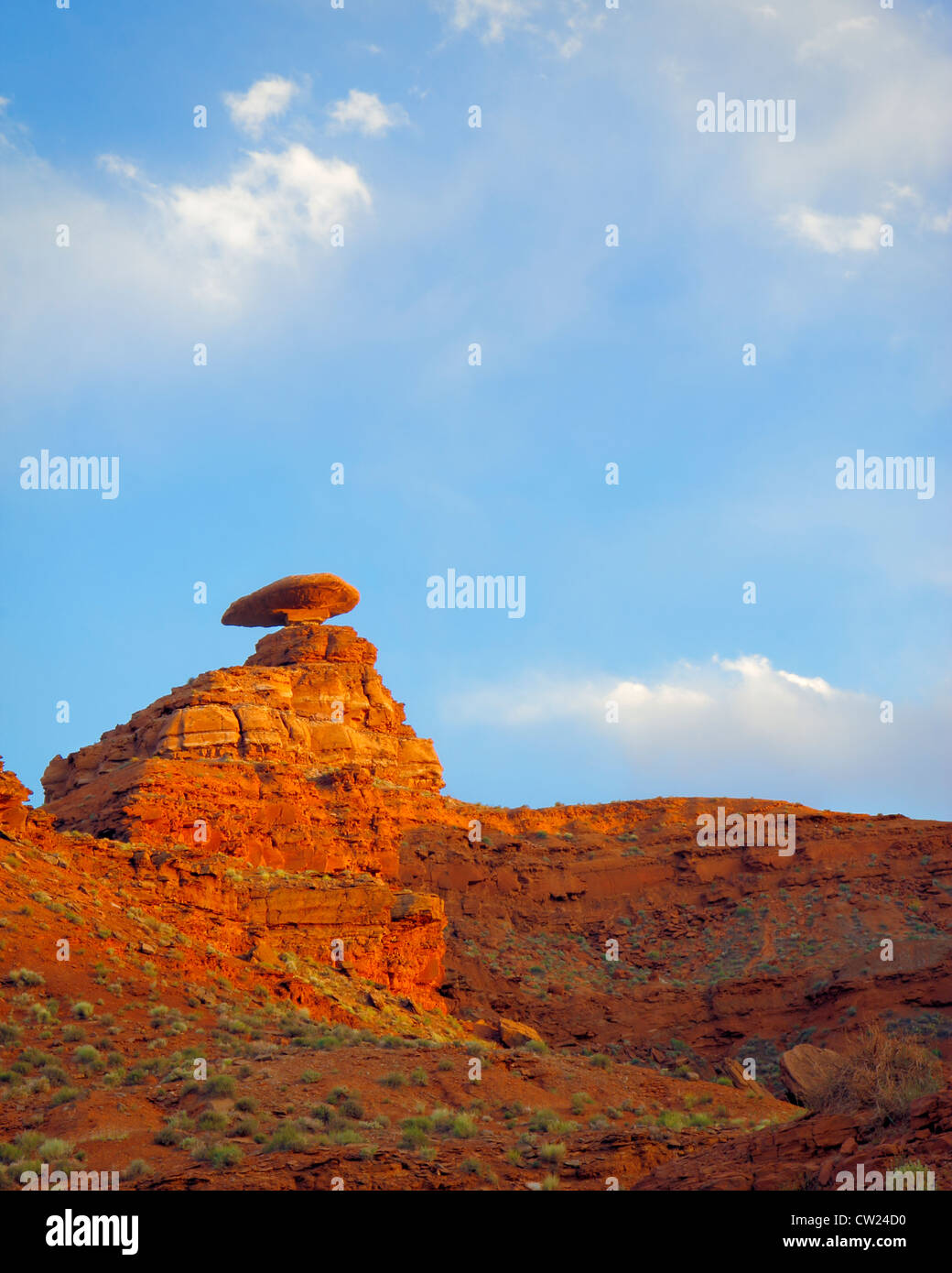 Precariously balanced hat shaped red rock formation beneath bright blue ...