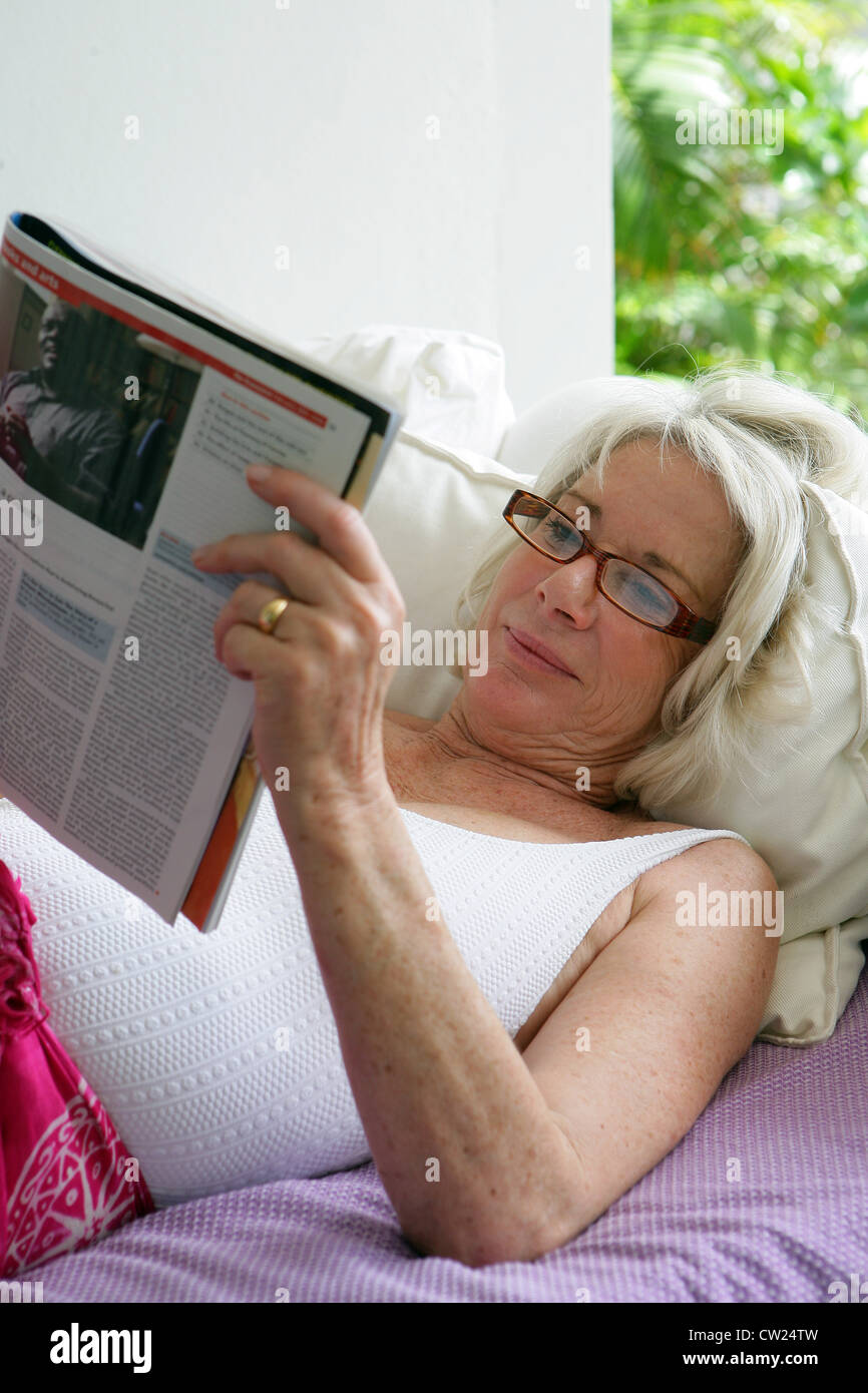 Elderly woman reading a magazine Stock Photo - Alamy