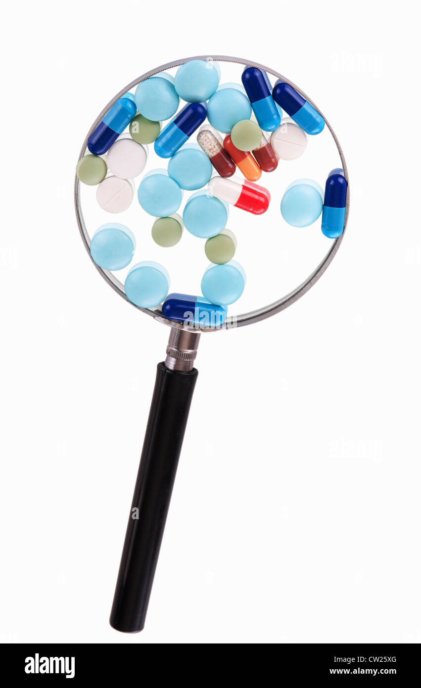 Group of different pills on magnifying glass. On white background Stock ...