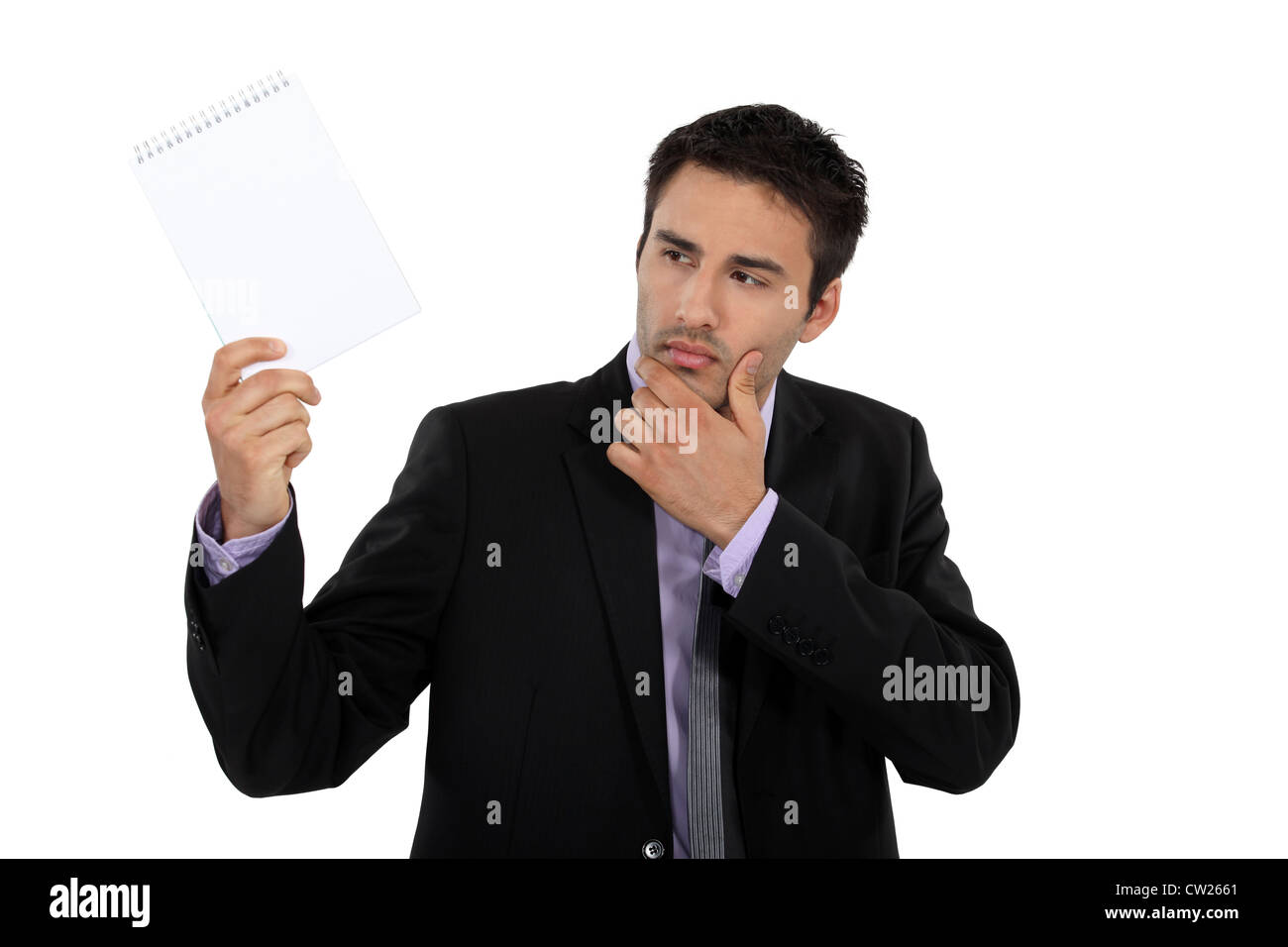 Businessman looking at notepad curiously Stock Photo - Alamy