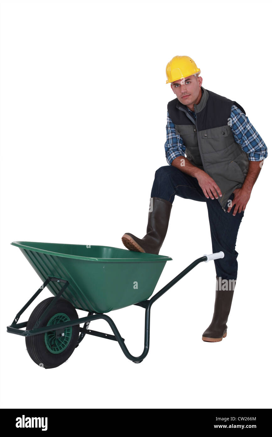 Man resting foot on wheelbarrow Stock Photo - Alamy