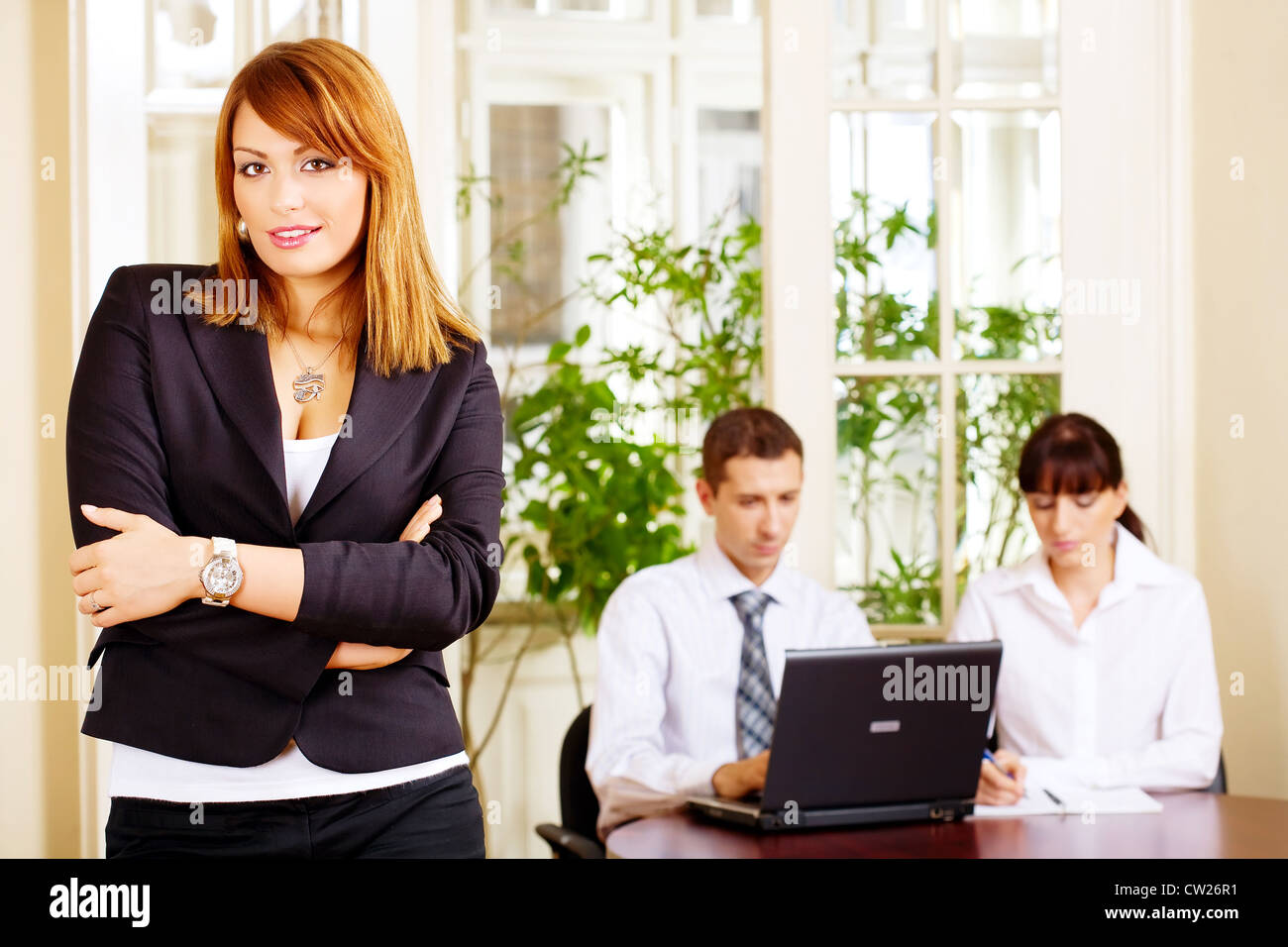 Pretty female manager with employers in office Stock Photo - Alamy