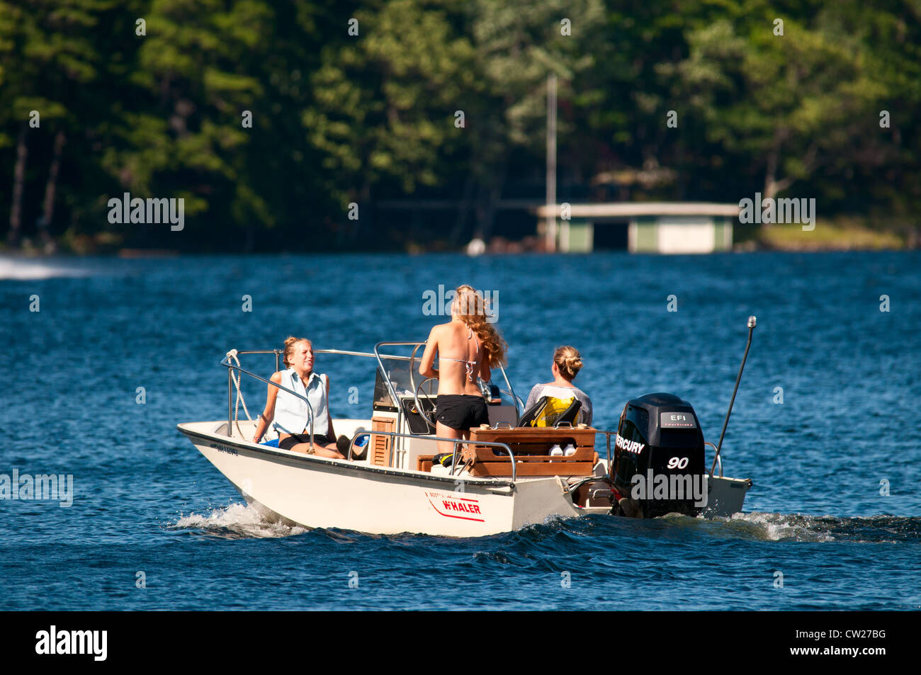 Three girls on a power boat Stock Photo - Alamy