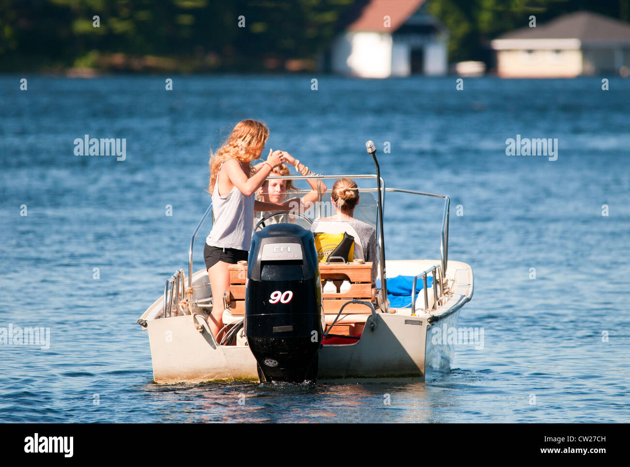 Three girls on a power boat Stock Photo - Alamy