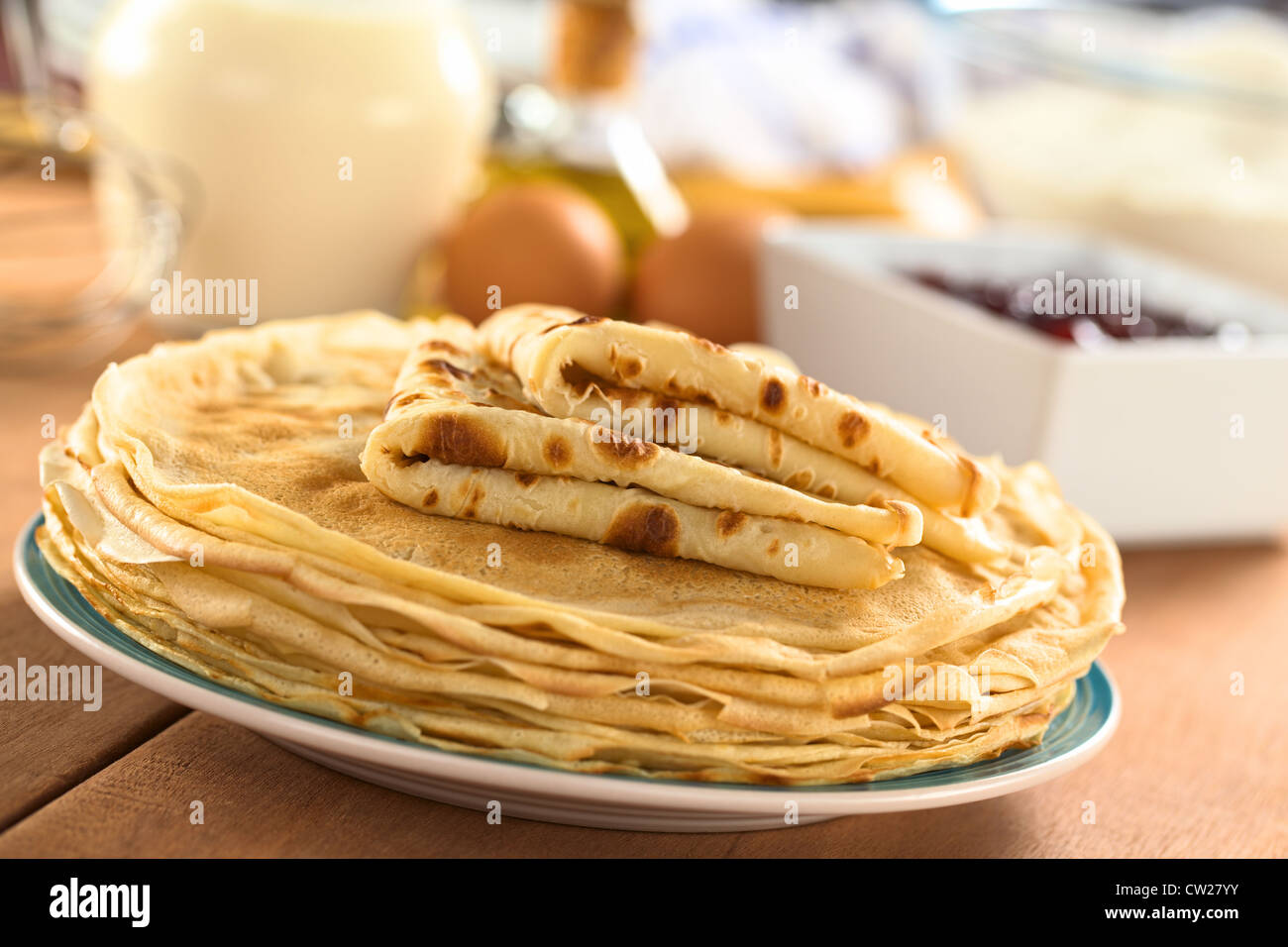 Fresh homemade crepes on plate with ingredients and strawberry jam in ...